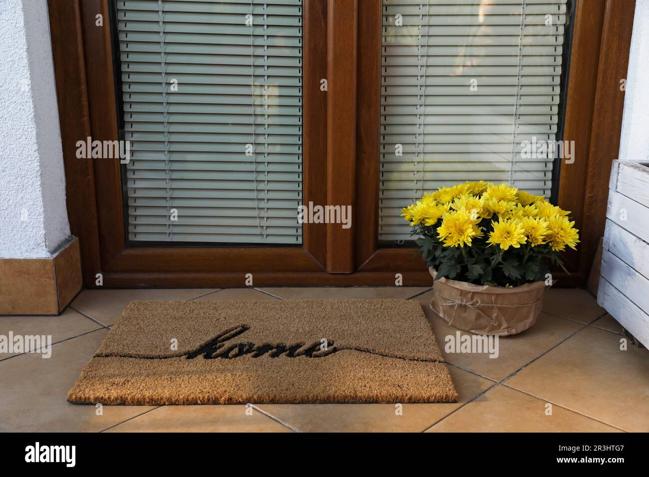 Doormat with word Home and flowers near entrance outdoors Stock Photo ...