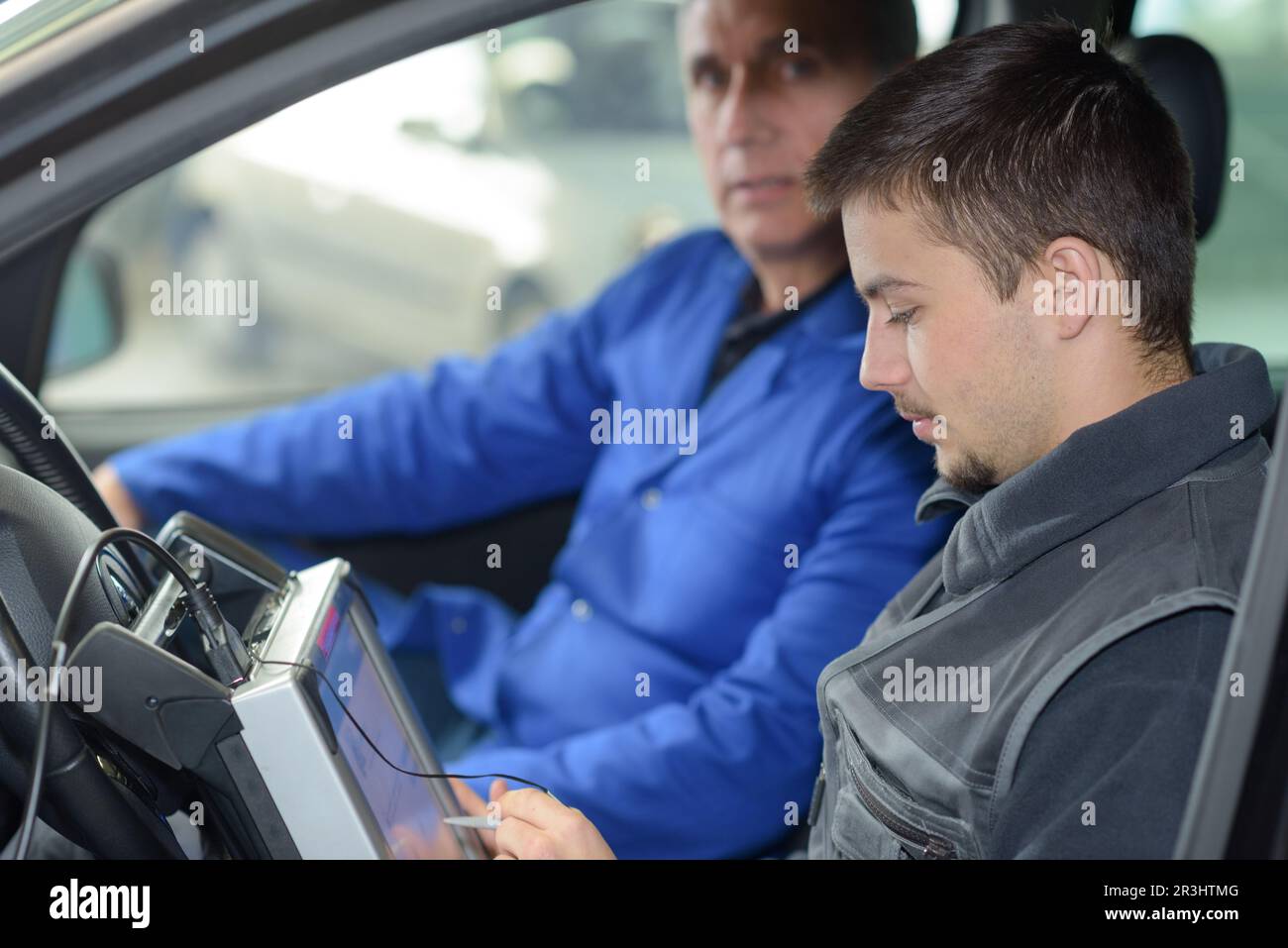 auto mechanic teacher and trainee performing tests at mechanic school ...