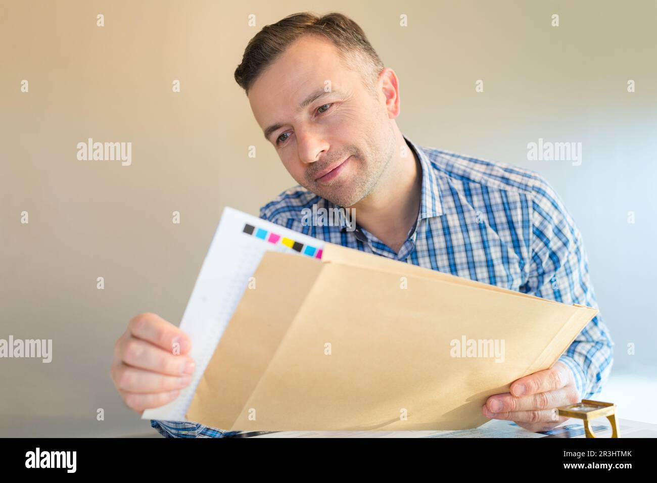 smiling man opening a letter with printing Stock Photo - Alamy