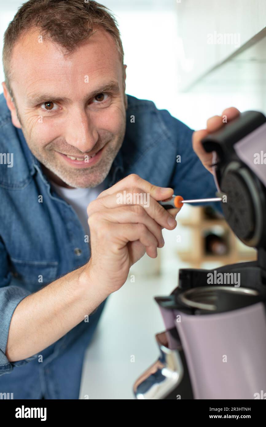 happy man repairing broken coffee machine Stock Photo - Alamy