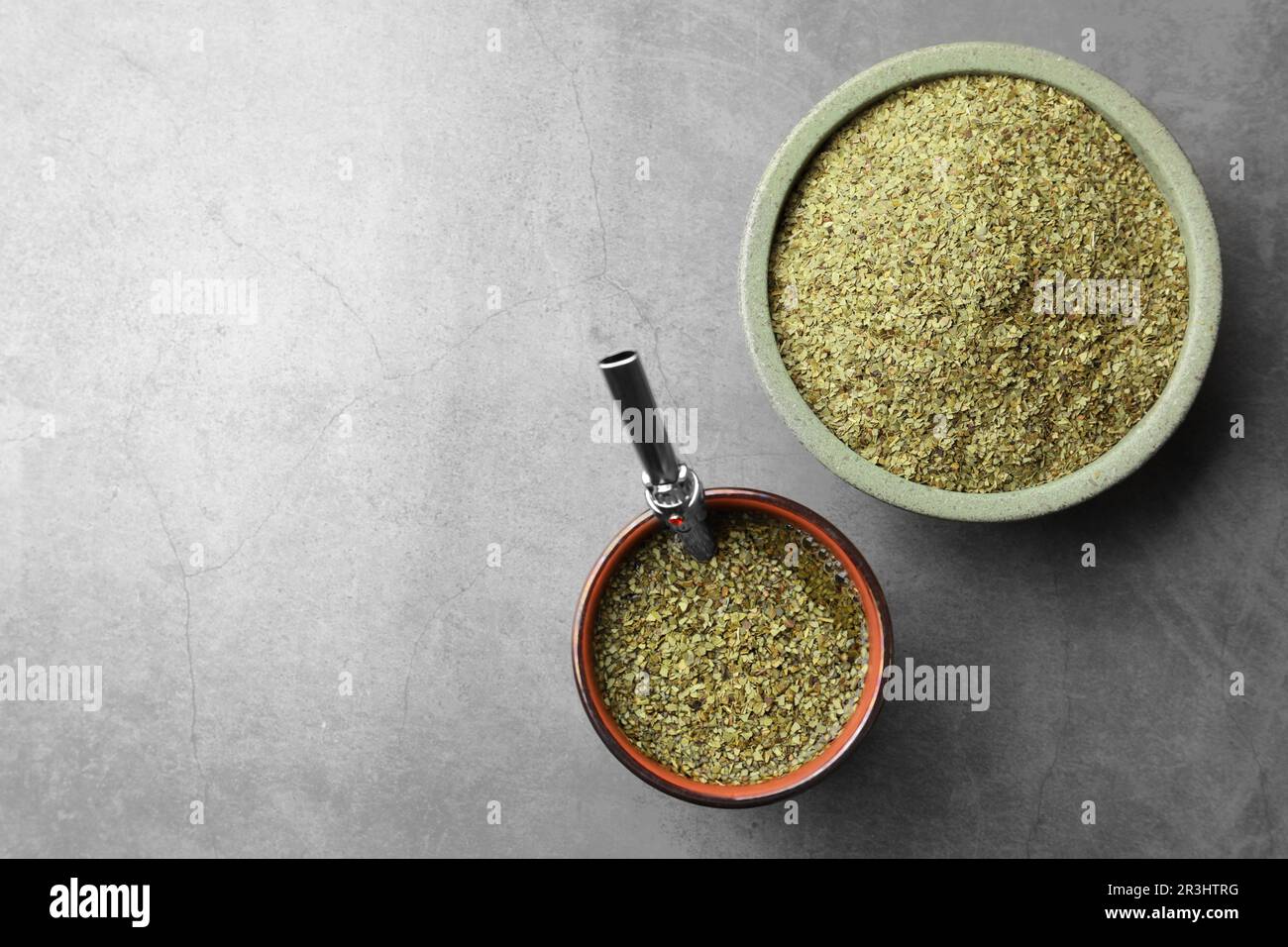 Guampa with bombilla and bowl of mate tea leaves on grey table, flat ...