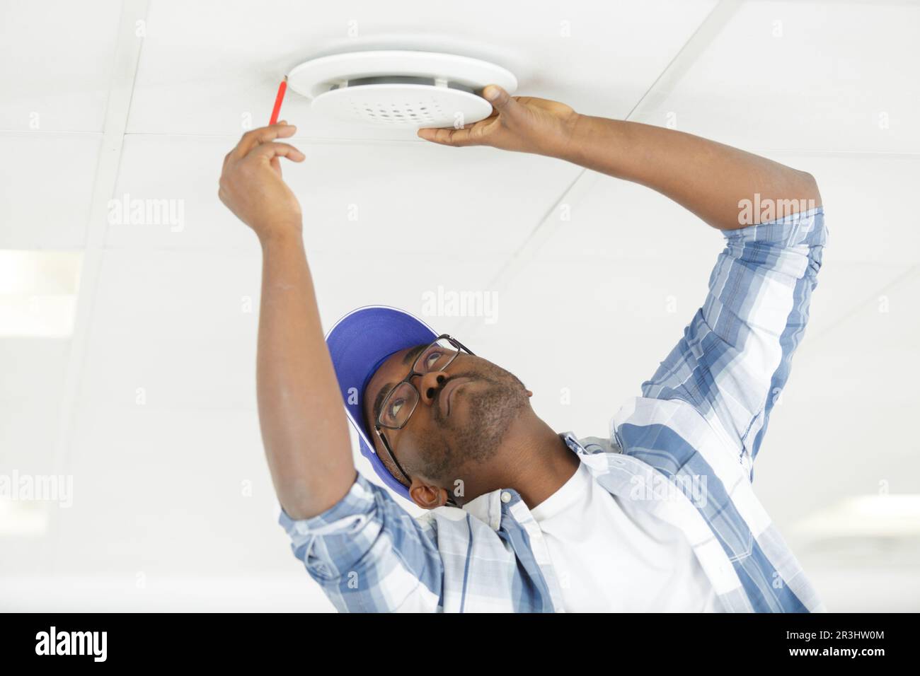 technician marking to install smoke detector on ceiling at home Stock ...