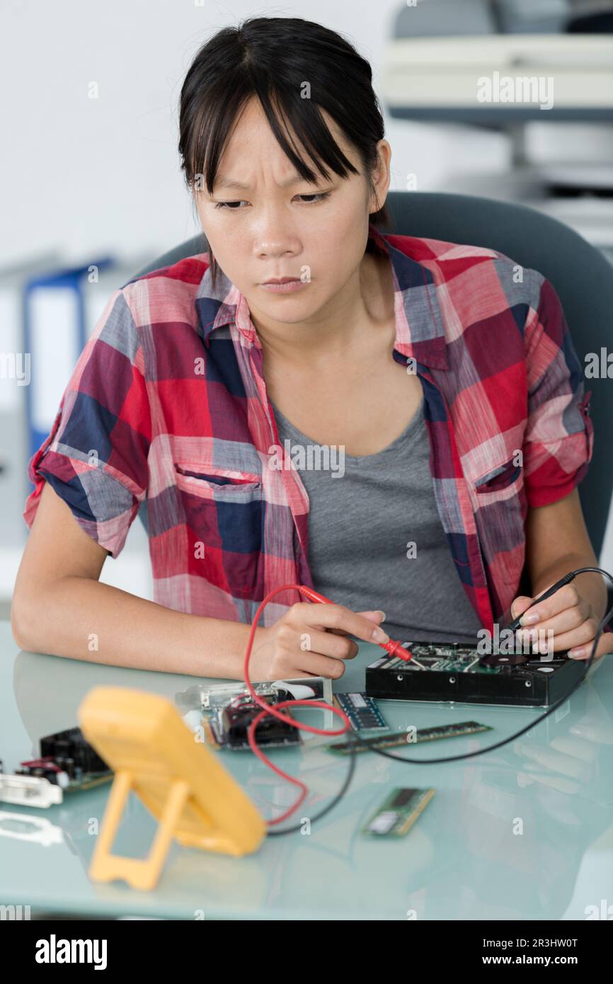 female asian computer technician using multimeter Stock Photo - Alamy