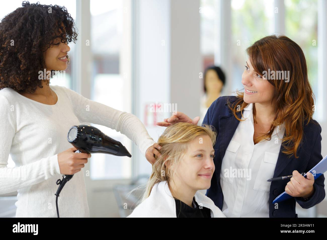 hairdresser using hairdryer during training course Stock Photo - Alamy