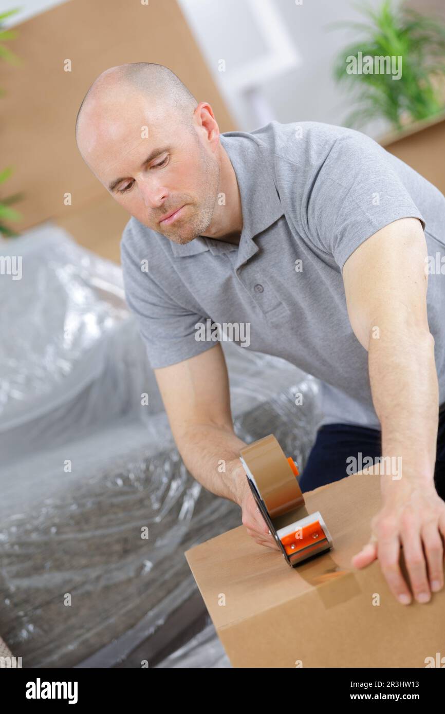 man packing things and taping boxes Stock Photo - Alamy