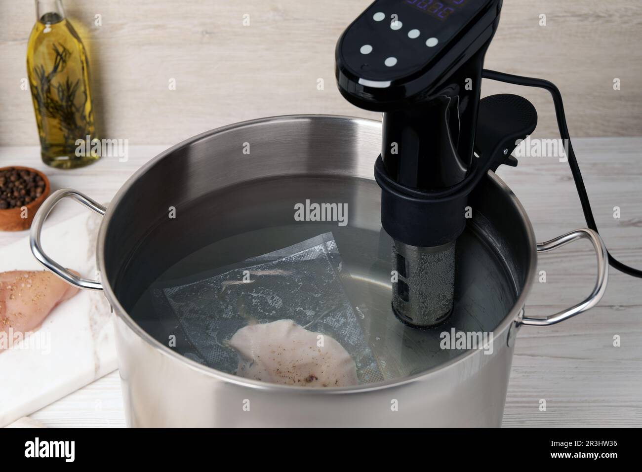 Thermal immersion circulator and vacuum packed meat in pot on white ...