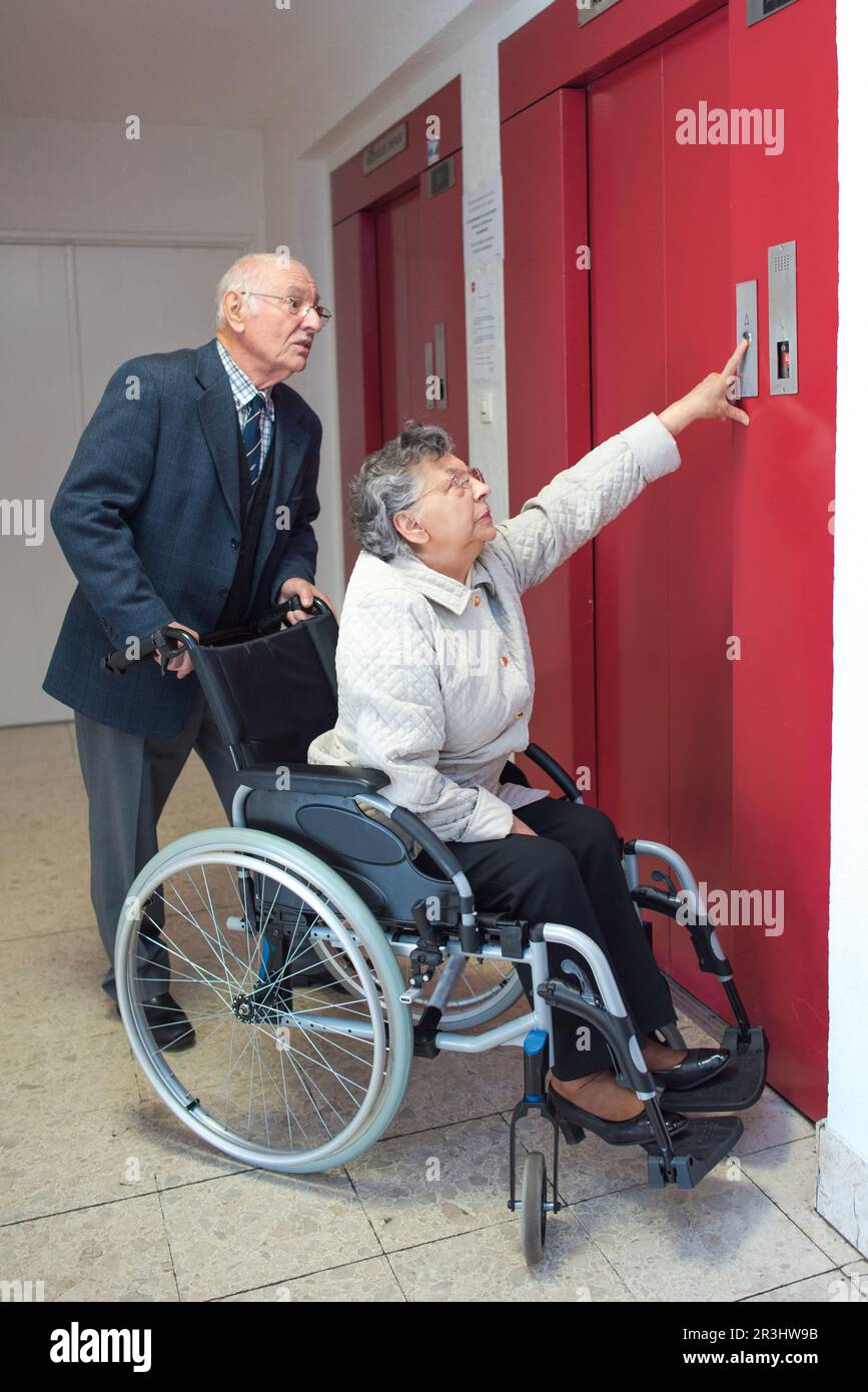 elderly woman in wheelchair reaching for lift button Stock Photo - Alamy