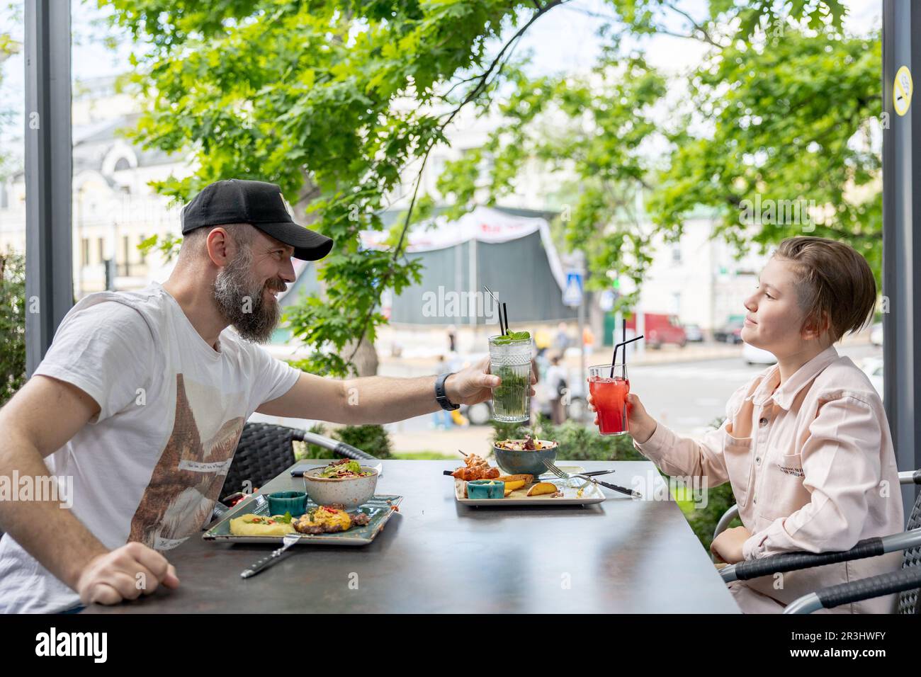 Father and son eating dinner in a restaurant. Satisfied family having ...