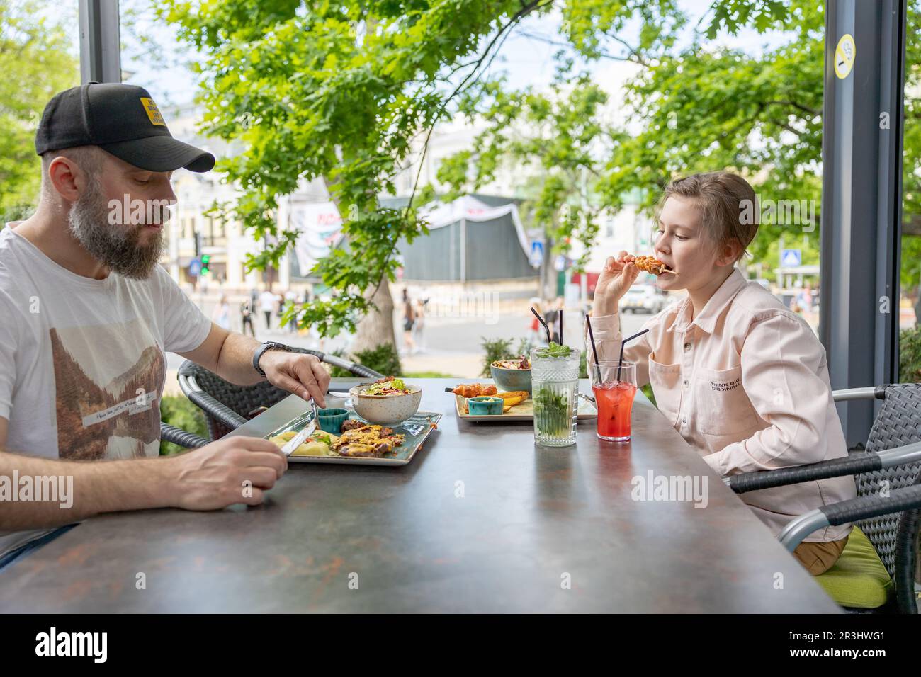 Father and son eating dinner in a restaurant. Satisfied family having ...