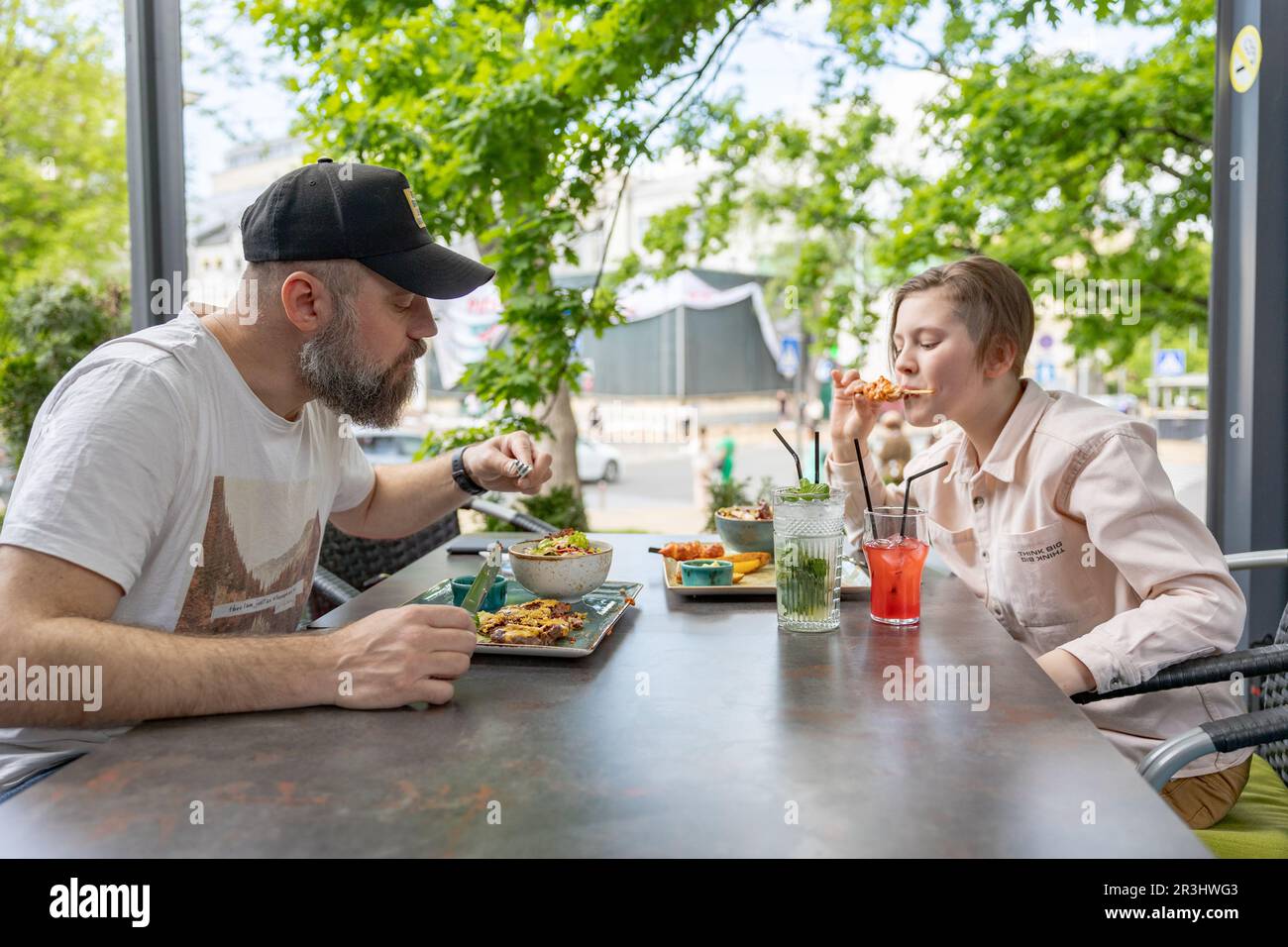 Father and son eating dinner in a restaurant. Satisfied family having ...