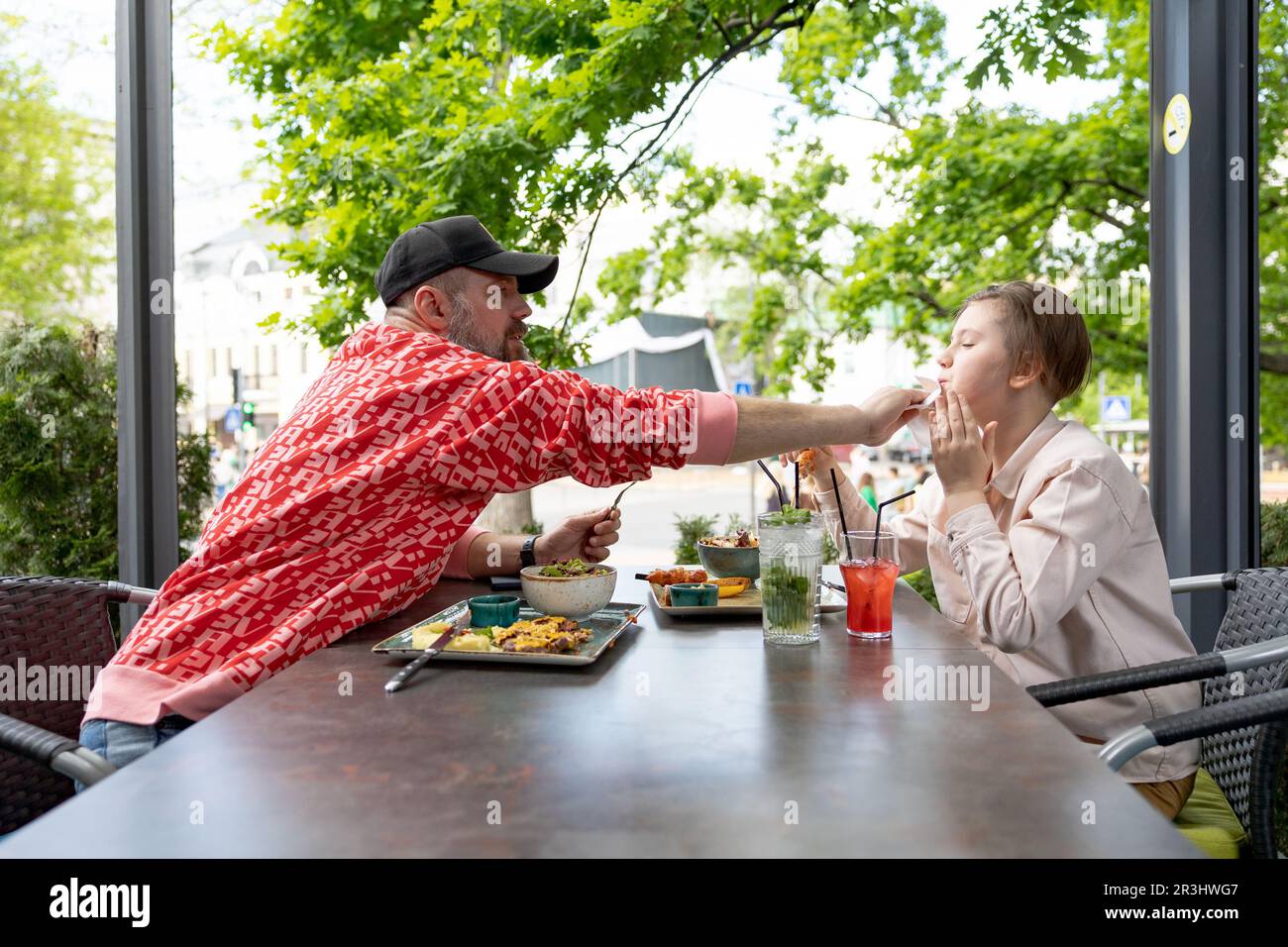 Father and son eating dinner in a restaurant. Satisfied family having ...