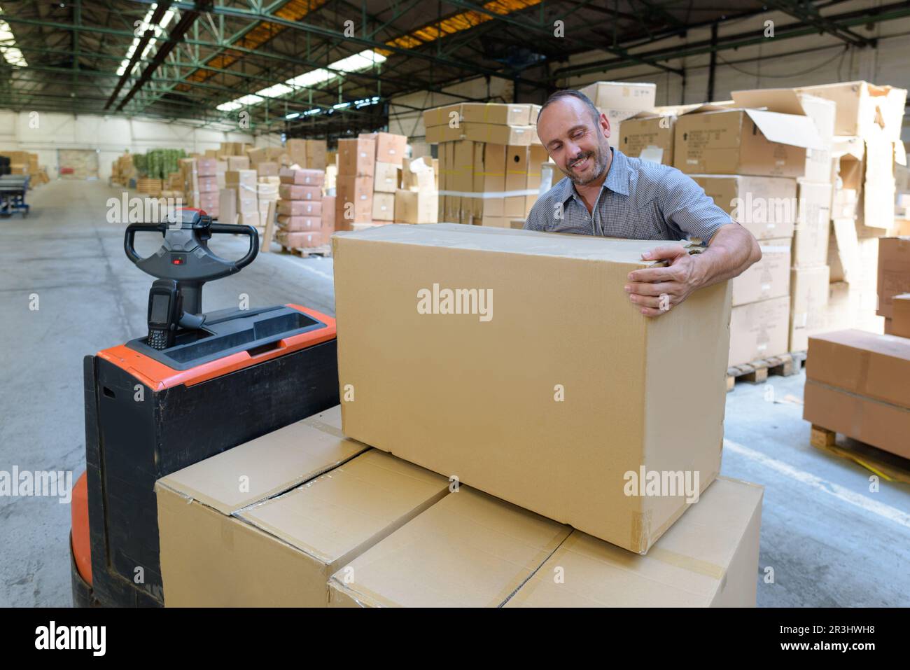 porter carrying boxes in a warehouse Stock Photo - Alamy