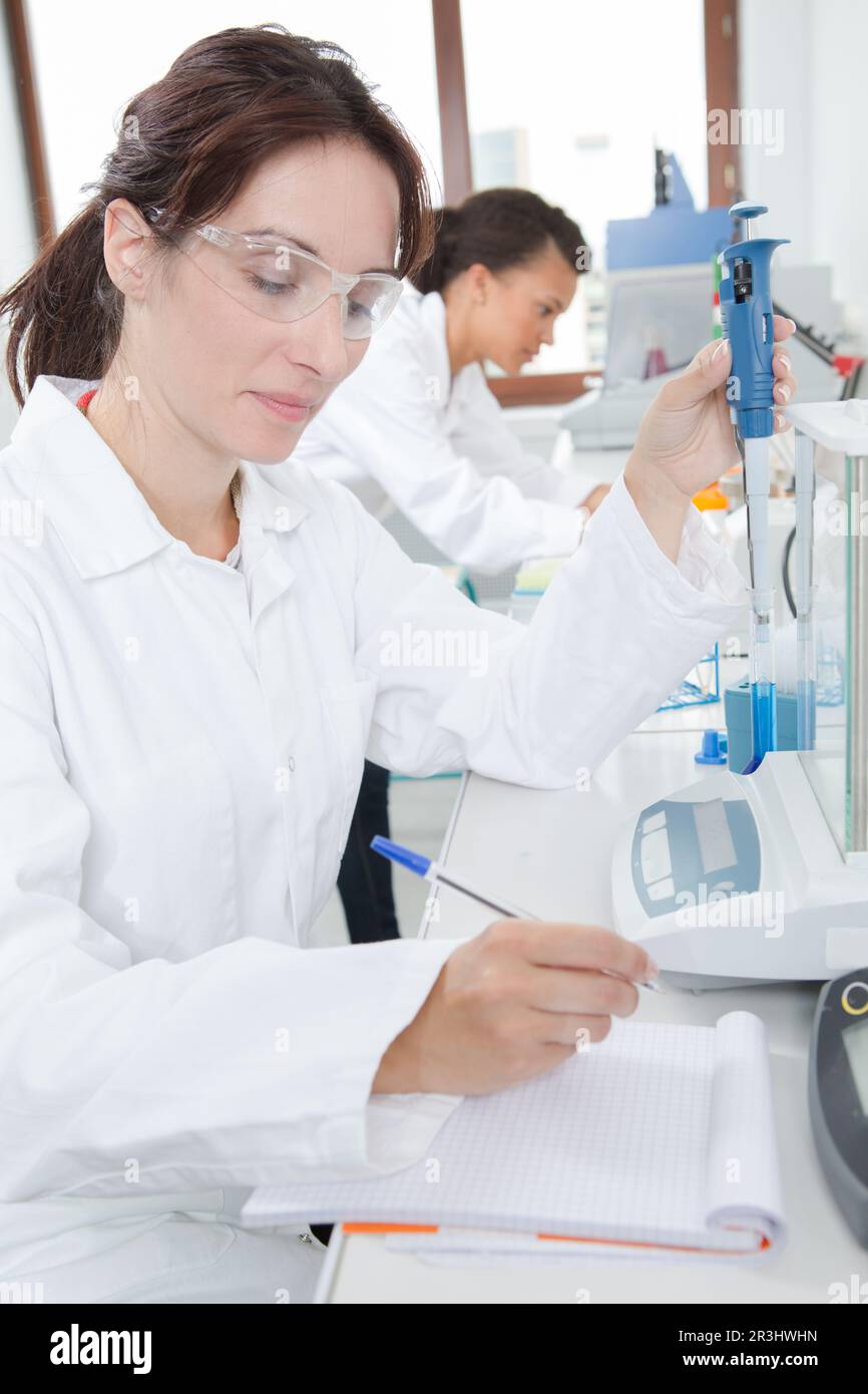 female researcher recording experiment in notebook Stock Photo - Alamy