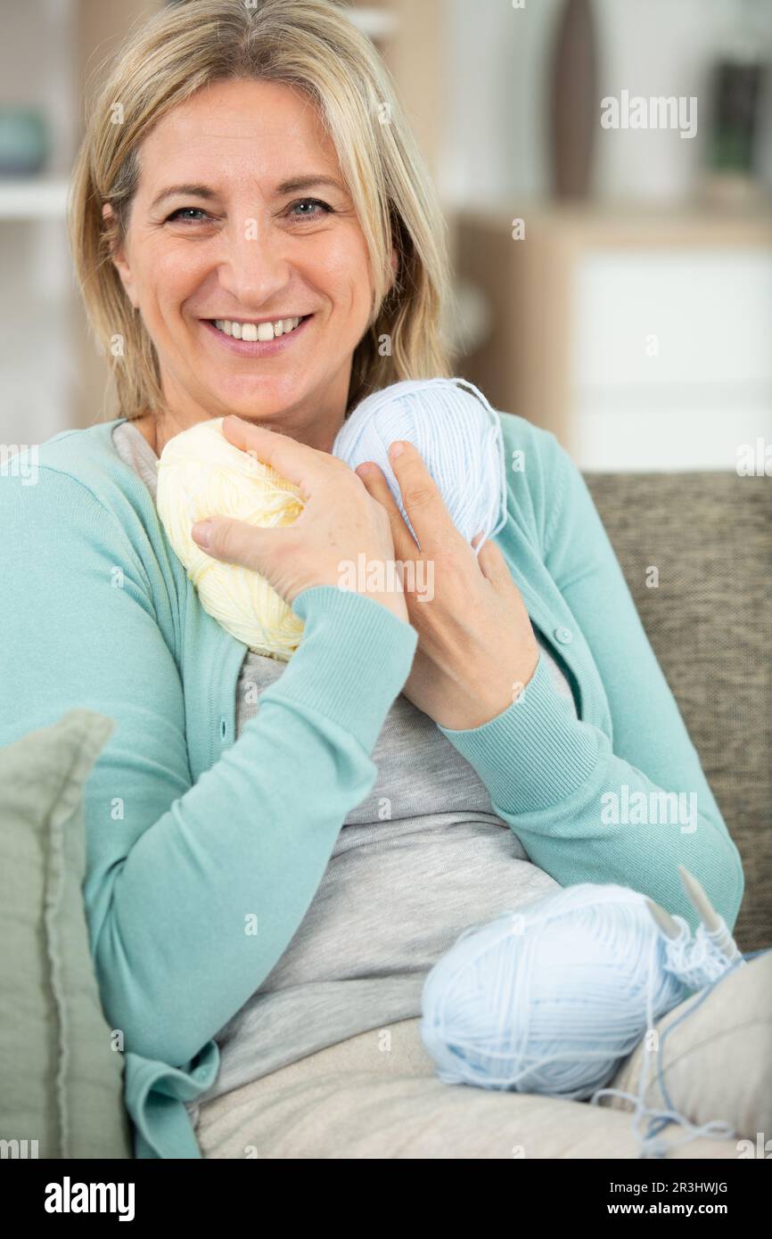 a happy middle aged woman loves knitting Stock Photo - Alamy