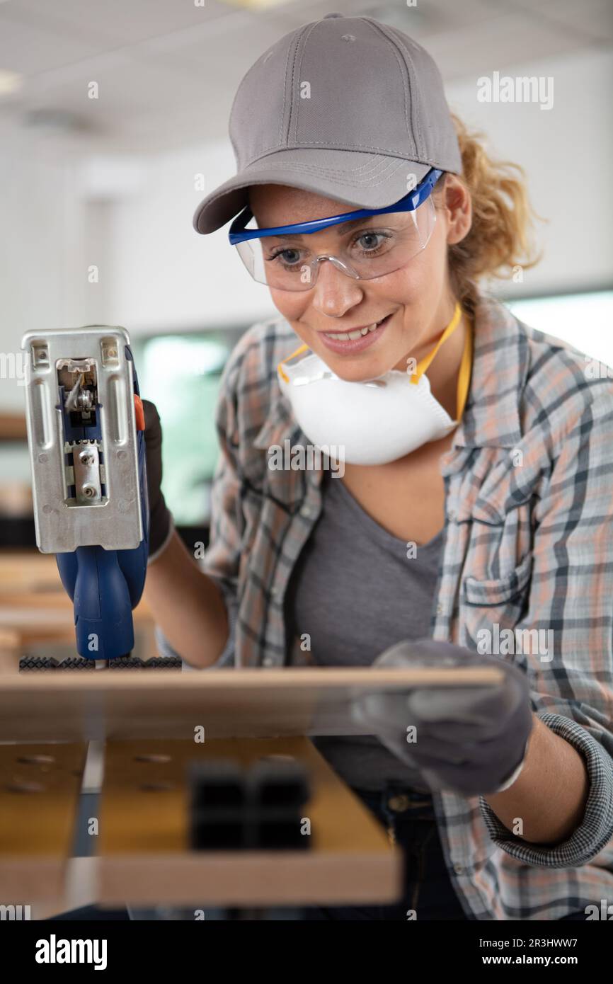female carpenter using electric sander for wood Stock Photo - Alamy