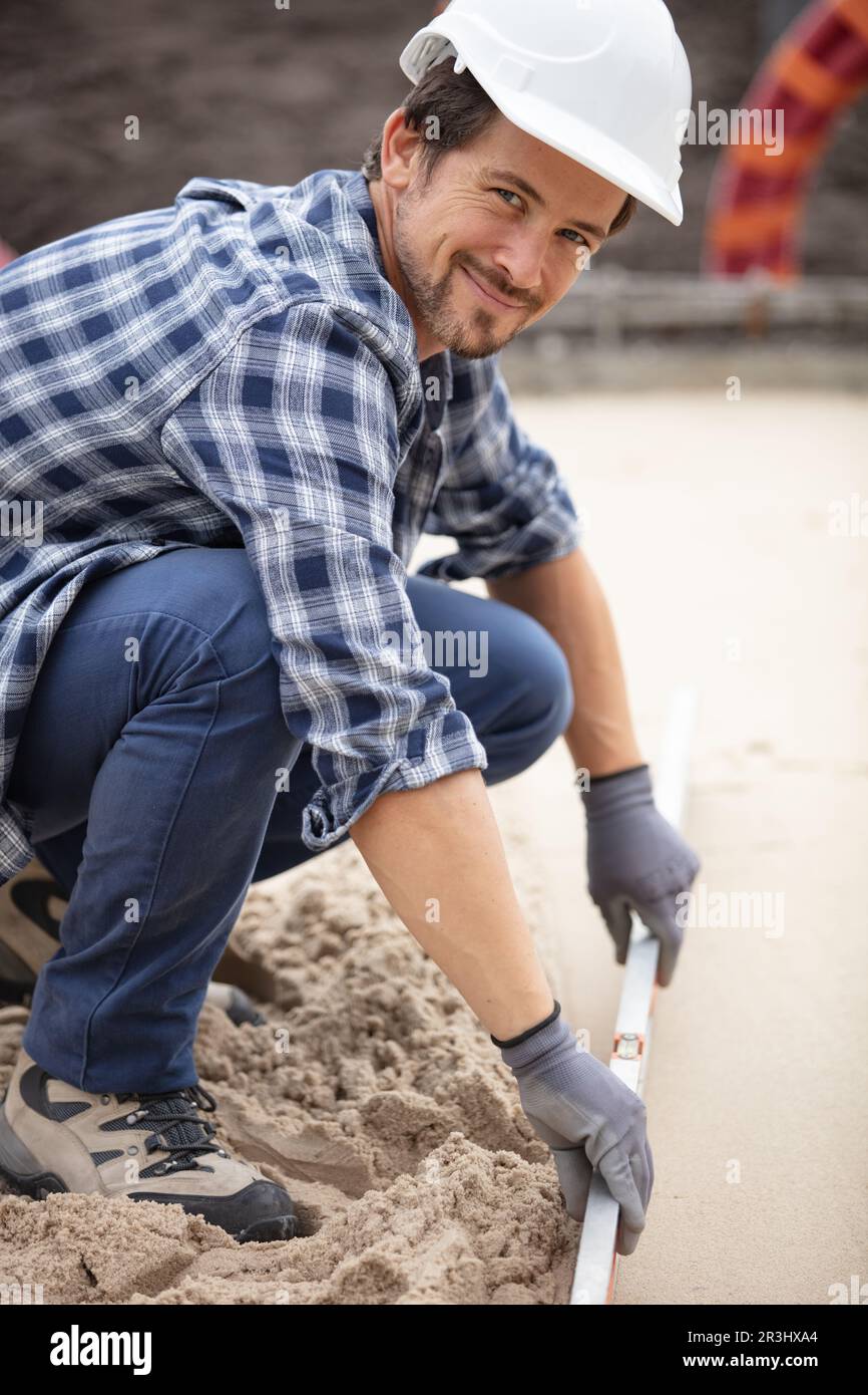 plasterer smoothing floor surface with leveling tool Stock Photo - Alamy