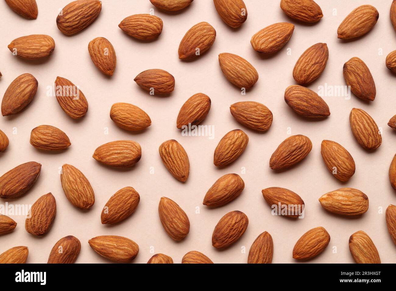 Delicious raw almonds on beige background, flat lay Stock Photo - Alamy
