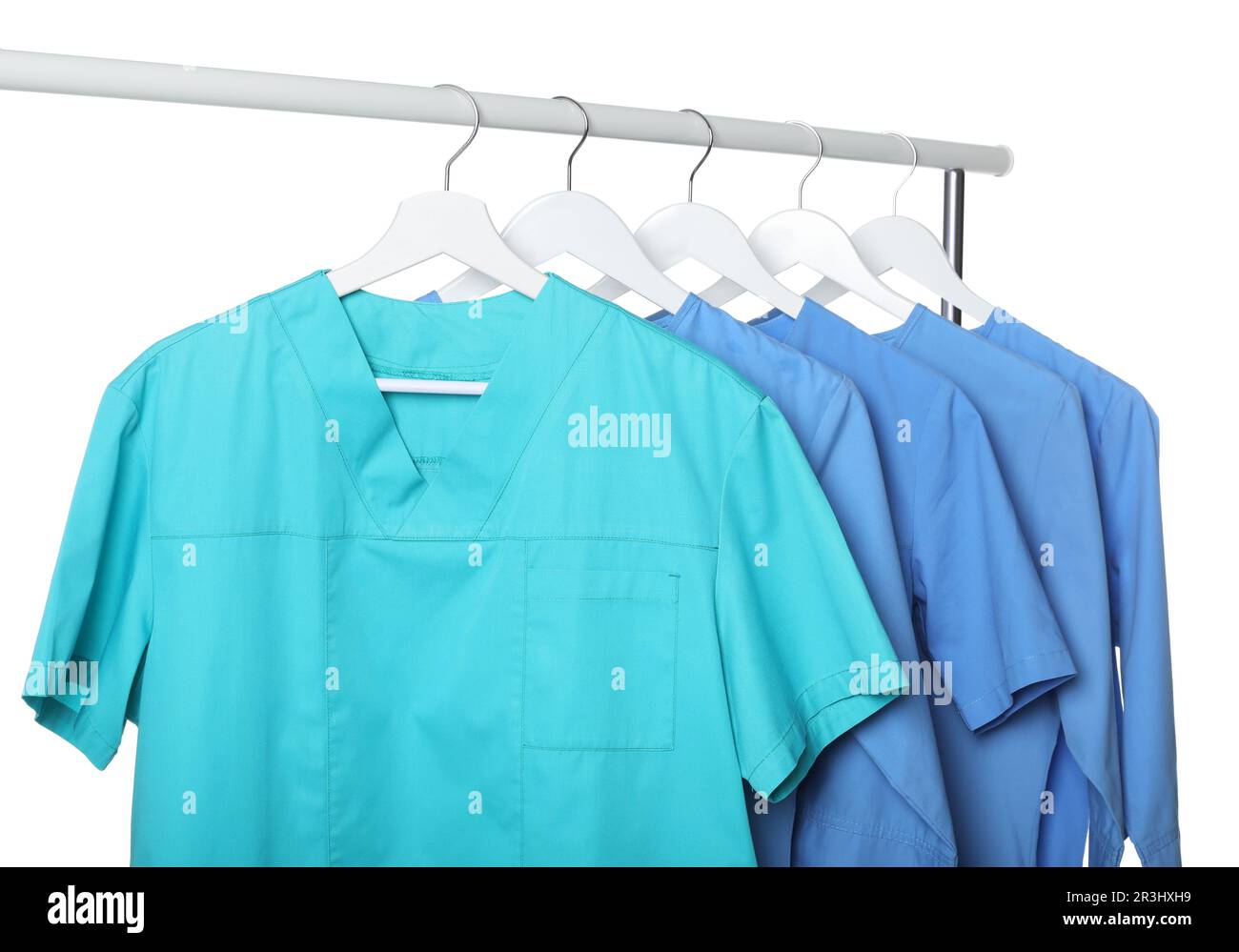 Turquoise and light blue medical uniforms on rack against white ...
