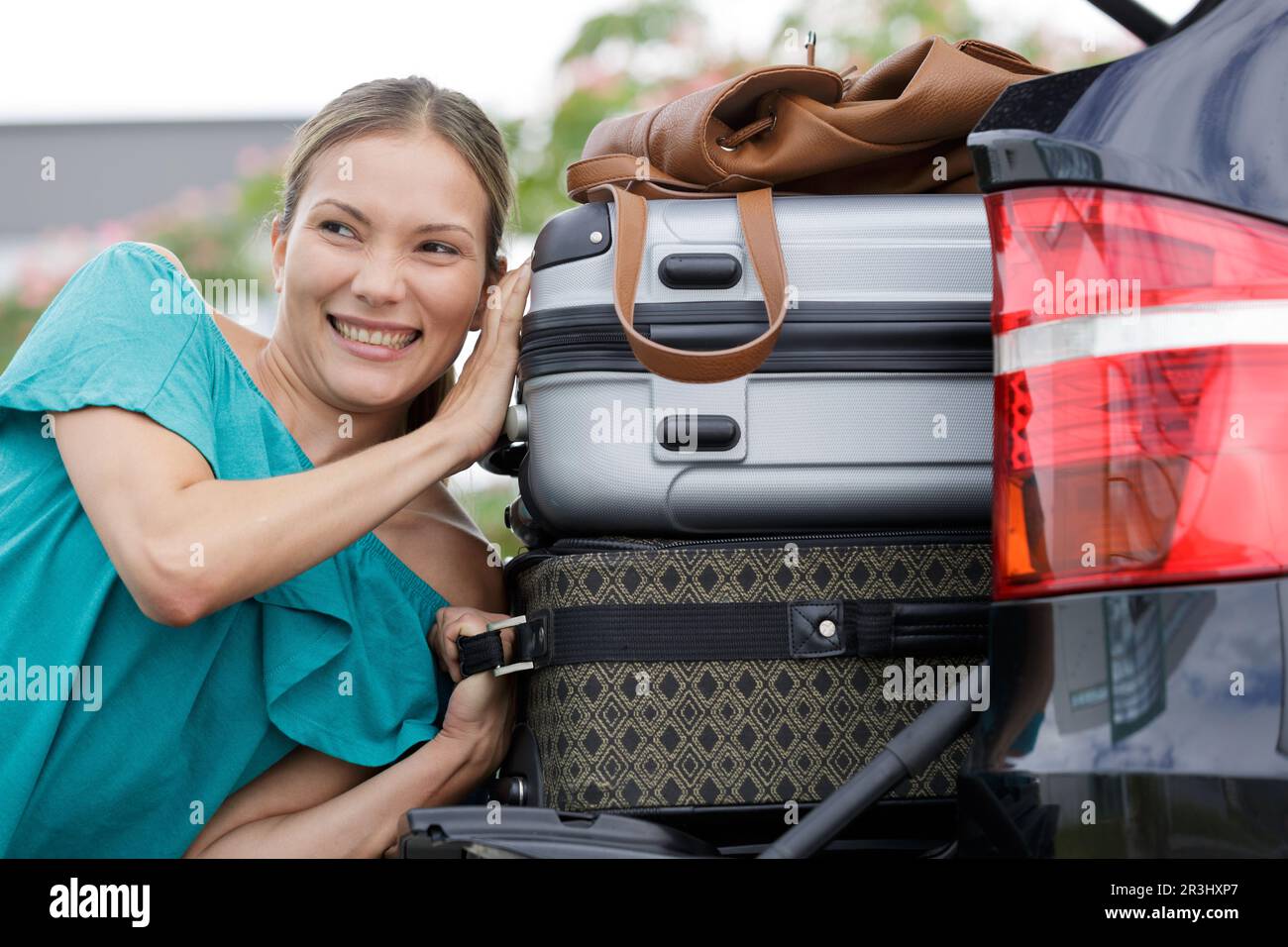 woman pushing baggage in car boot Stock Photo - Alamy