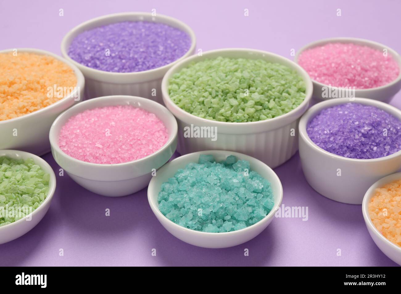 Different types of aromatic sea salt on purple background Stock Photo ...