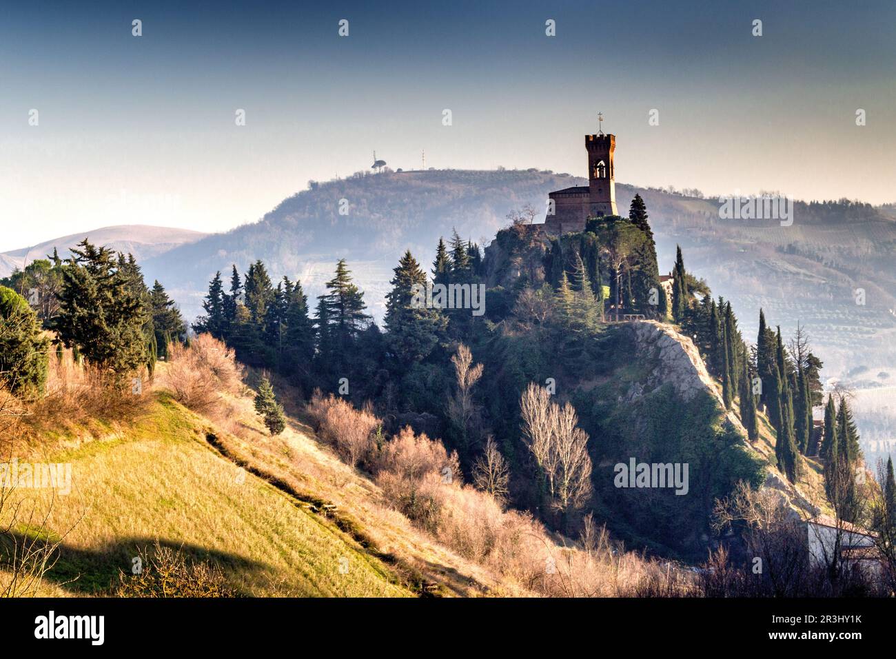 Crenellated clock tower among hills in the fog Stock Photo - Alamy