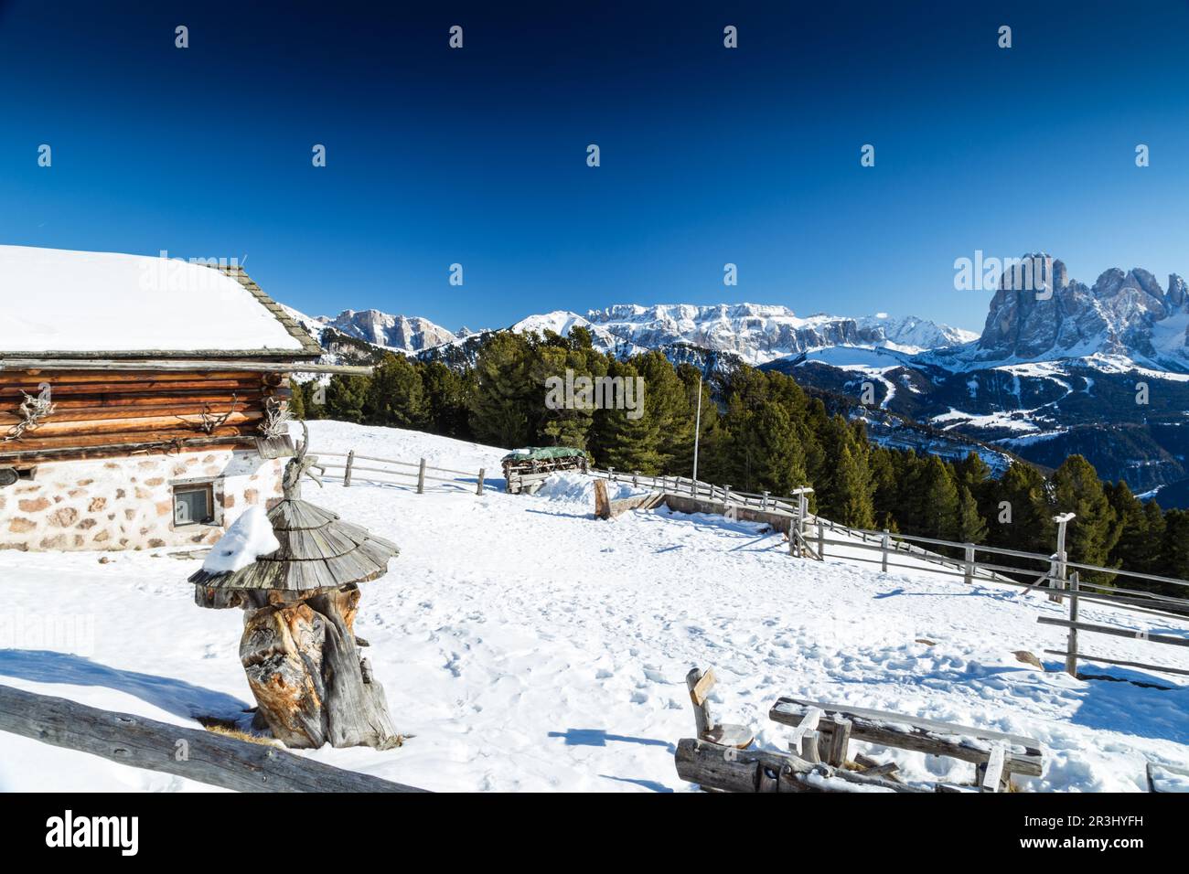 High-altitude mountain hut in front of a panorama of snow-capped peaks ...