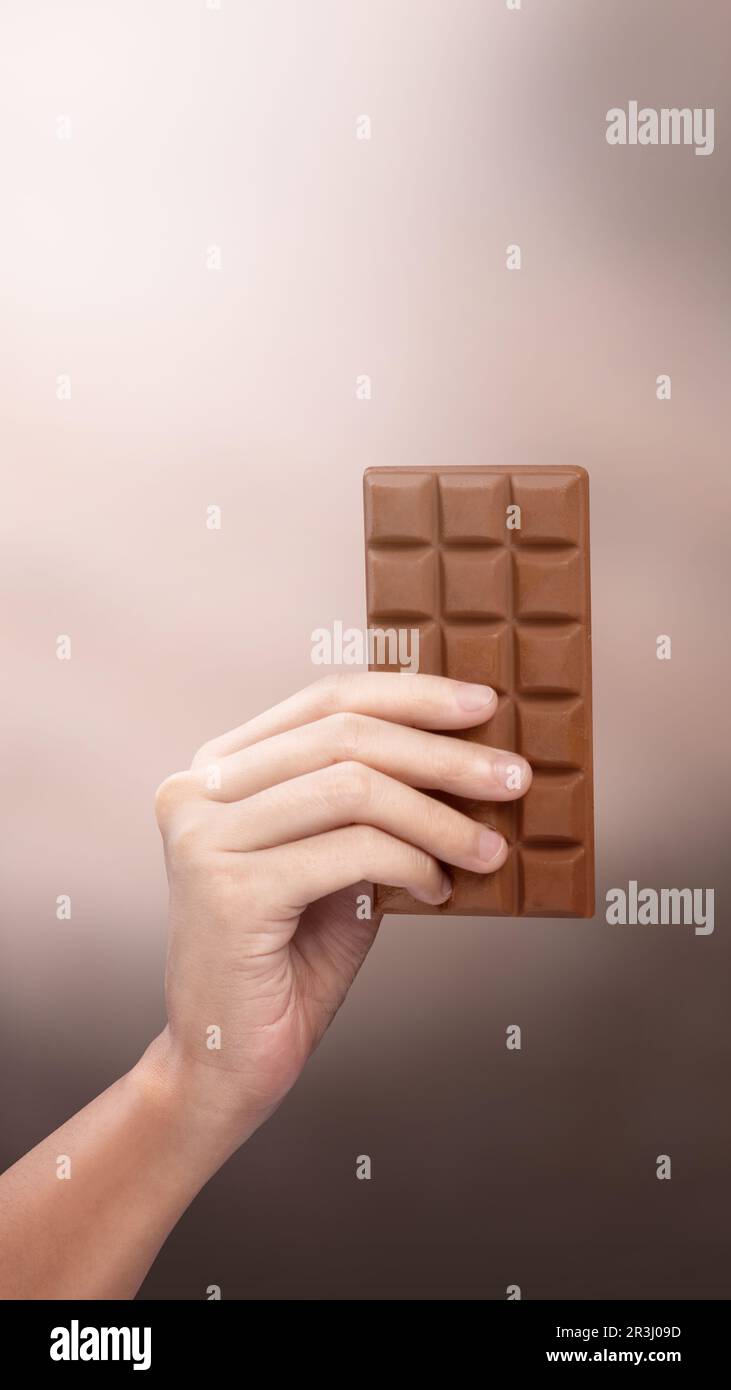 Human hand holding the chocolate bar. World chocolate day concept Stock ...