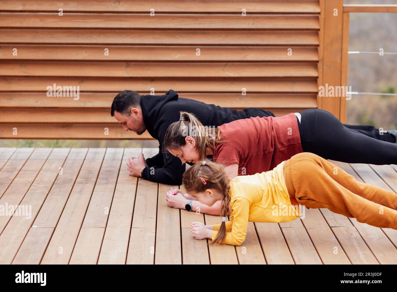 Happy family are stretching outdoors. Attractive mom, handsome dad and ...
