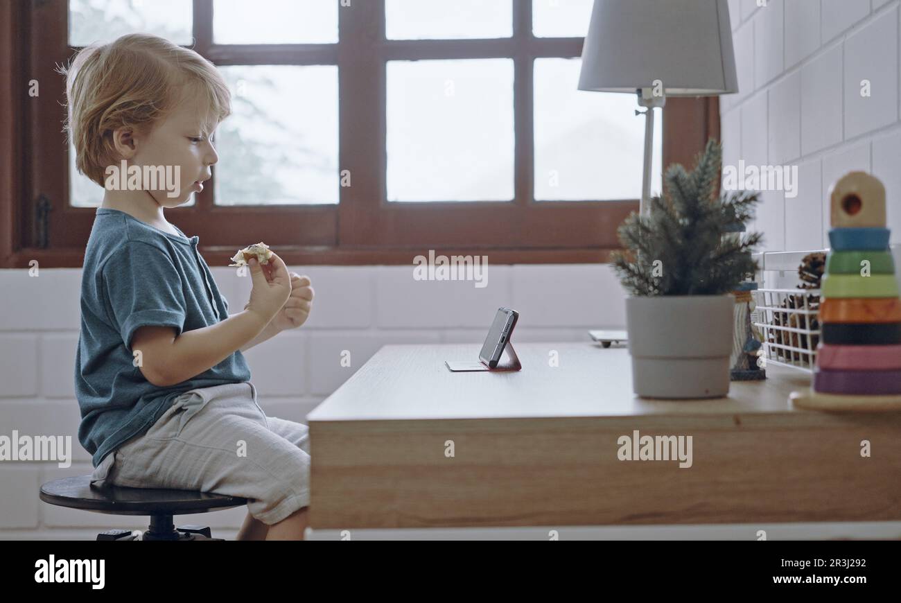 Little boy using smartphone, looking at screen, curious child holding ...