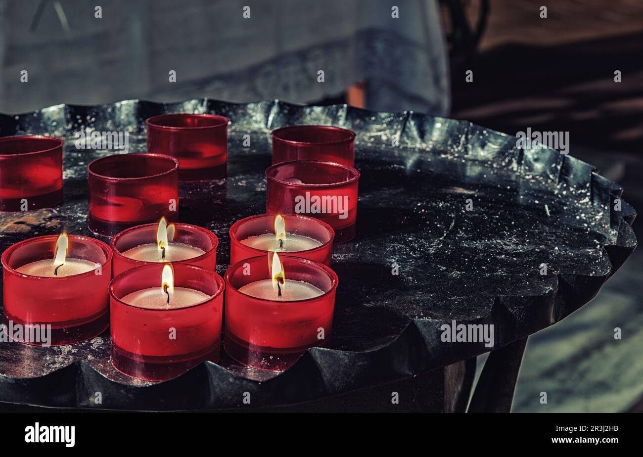 Red votive candles on iron candlestick Stock Photo - Alamy
