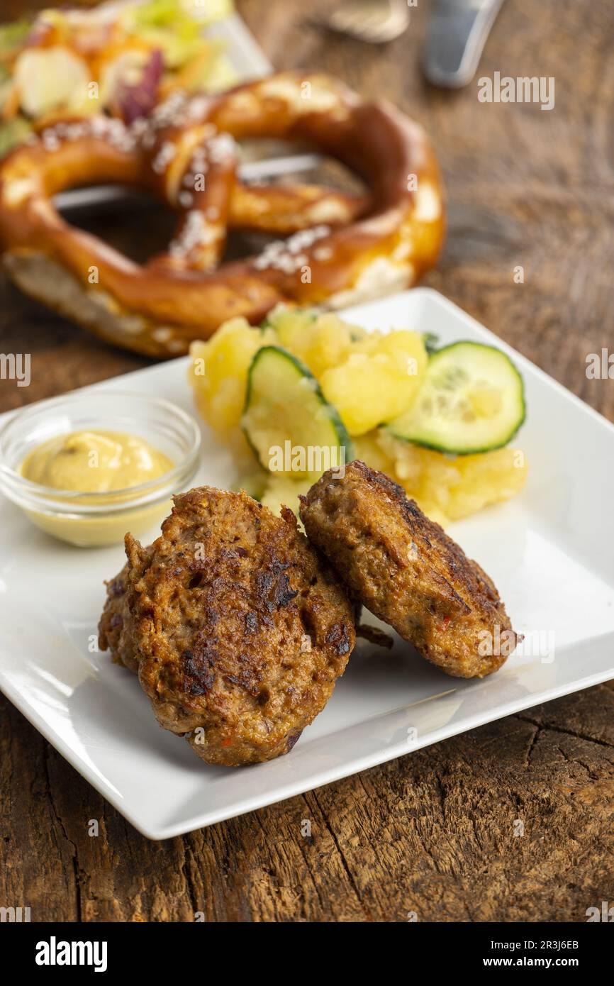 Bavarian meat patty with potato salad Stock Photo - Alamy
