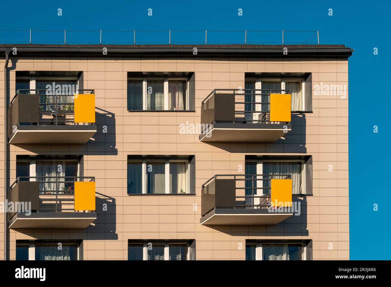 Top part of block of flats building with blue sky Stock Photo - Alamy
