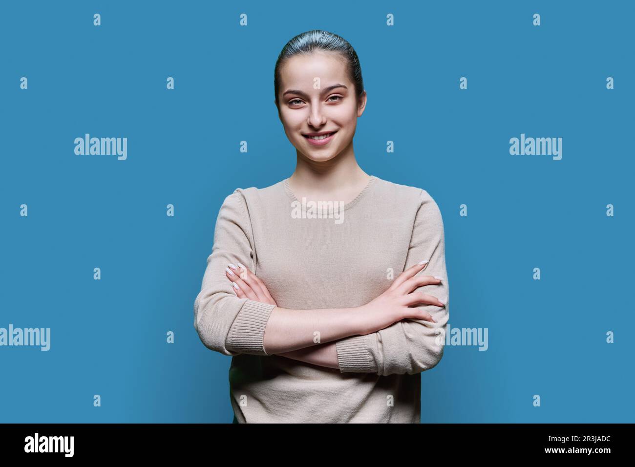 Portrait of smiling high school student girl on blue background Stock ...