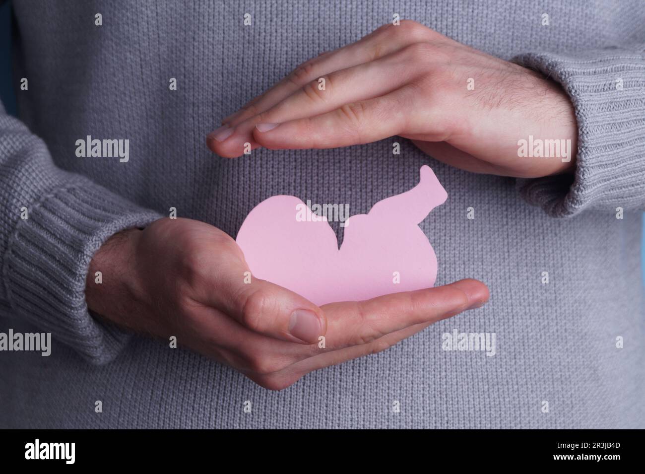 Female health. Man holding newborn paper figure, closeup Stock Photo ...
