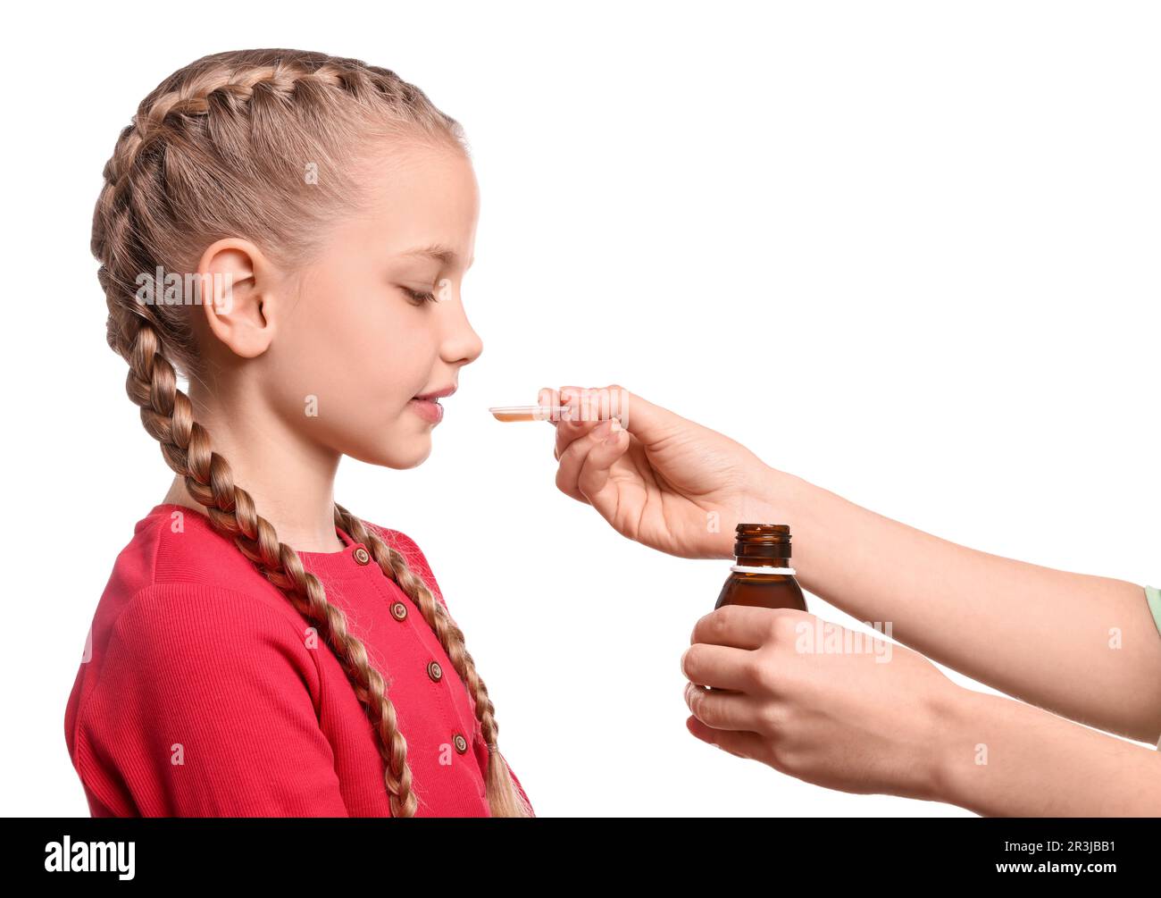 Mother giving syrup to her daughter from dosing spoon against white ...
