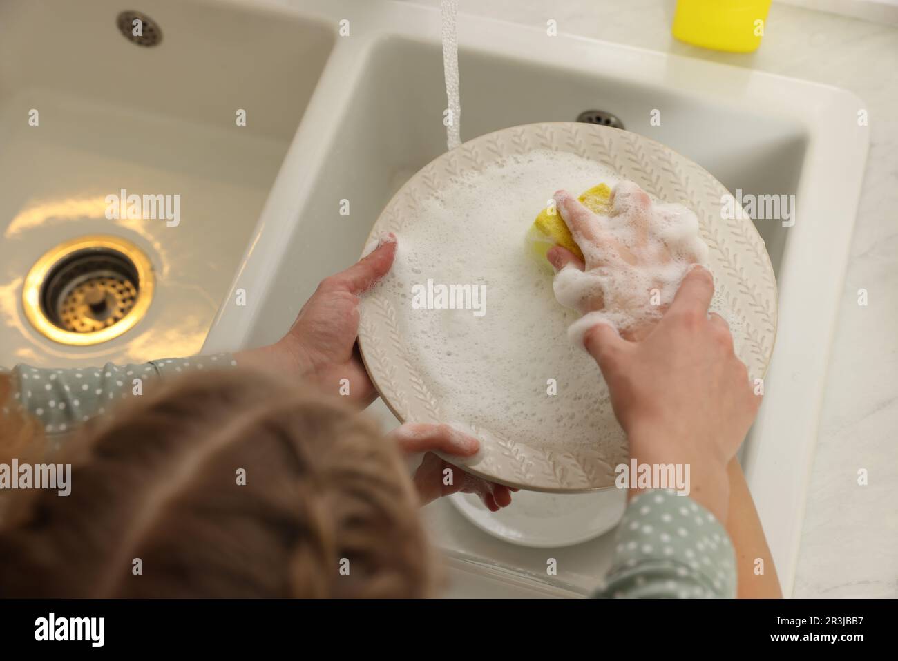 Mother and daughter washing plate in sink, above view Stock Photo - Alamy