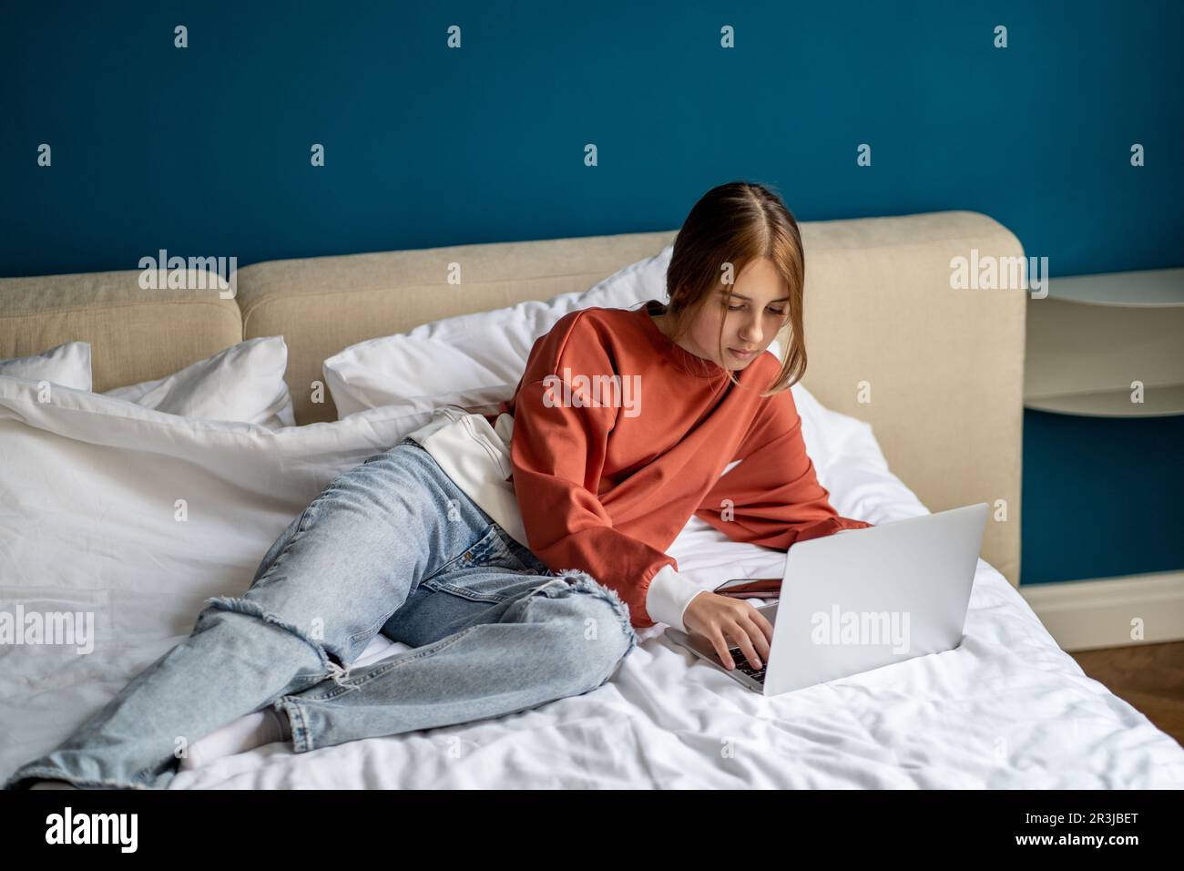 Teenager girl resting on bed with laptop Stock Photo - Alamy