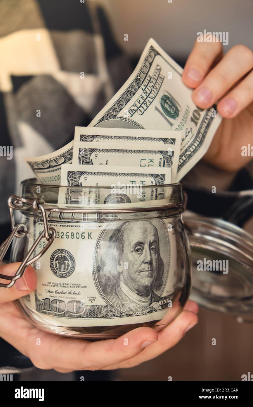 Dollar banknote saving money in glass jar. Unrecognizable woman ...