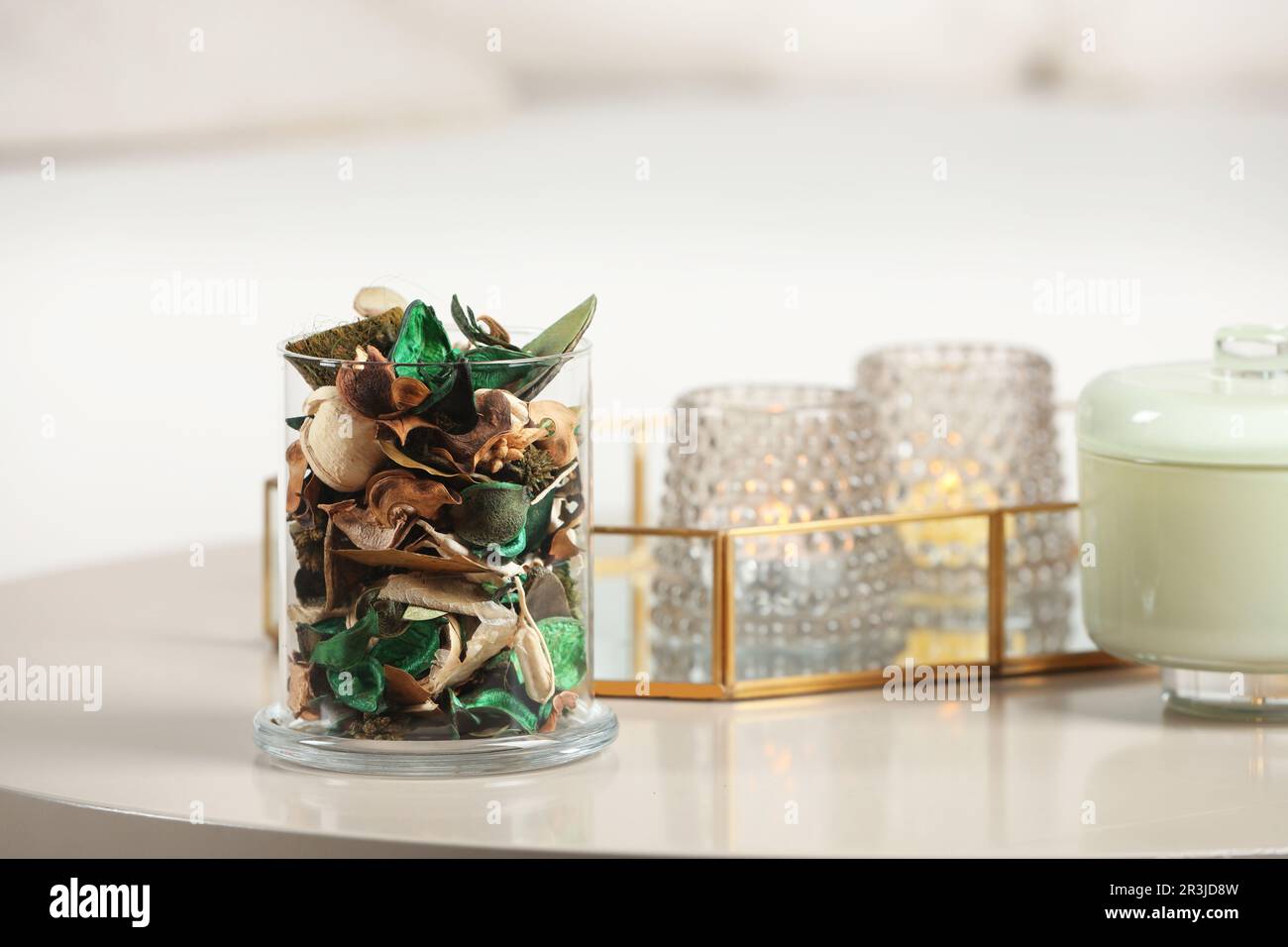Aromatic potpourri of dried flowers in glass jar on white table indoors ...