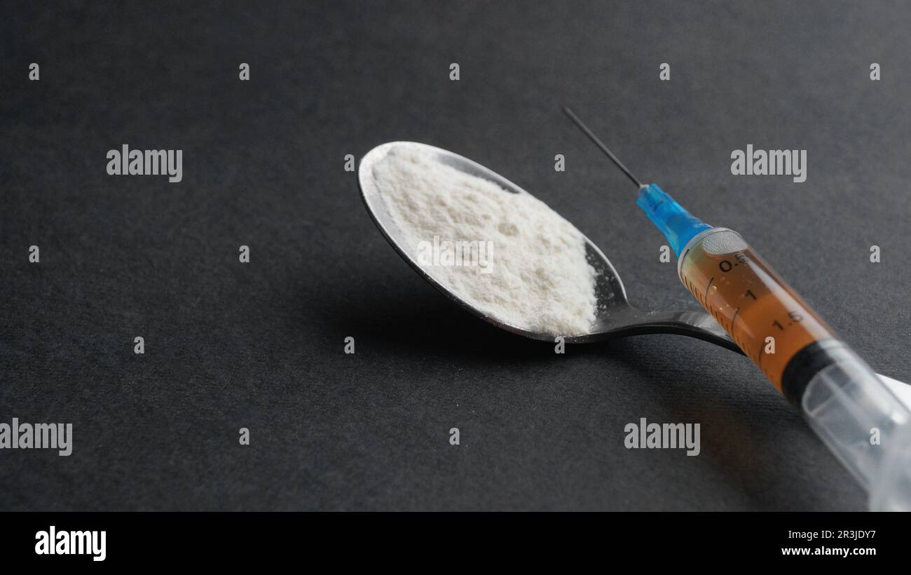 Spoon with powder, syringe on black background, closeup and space for ...