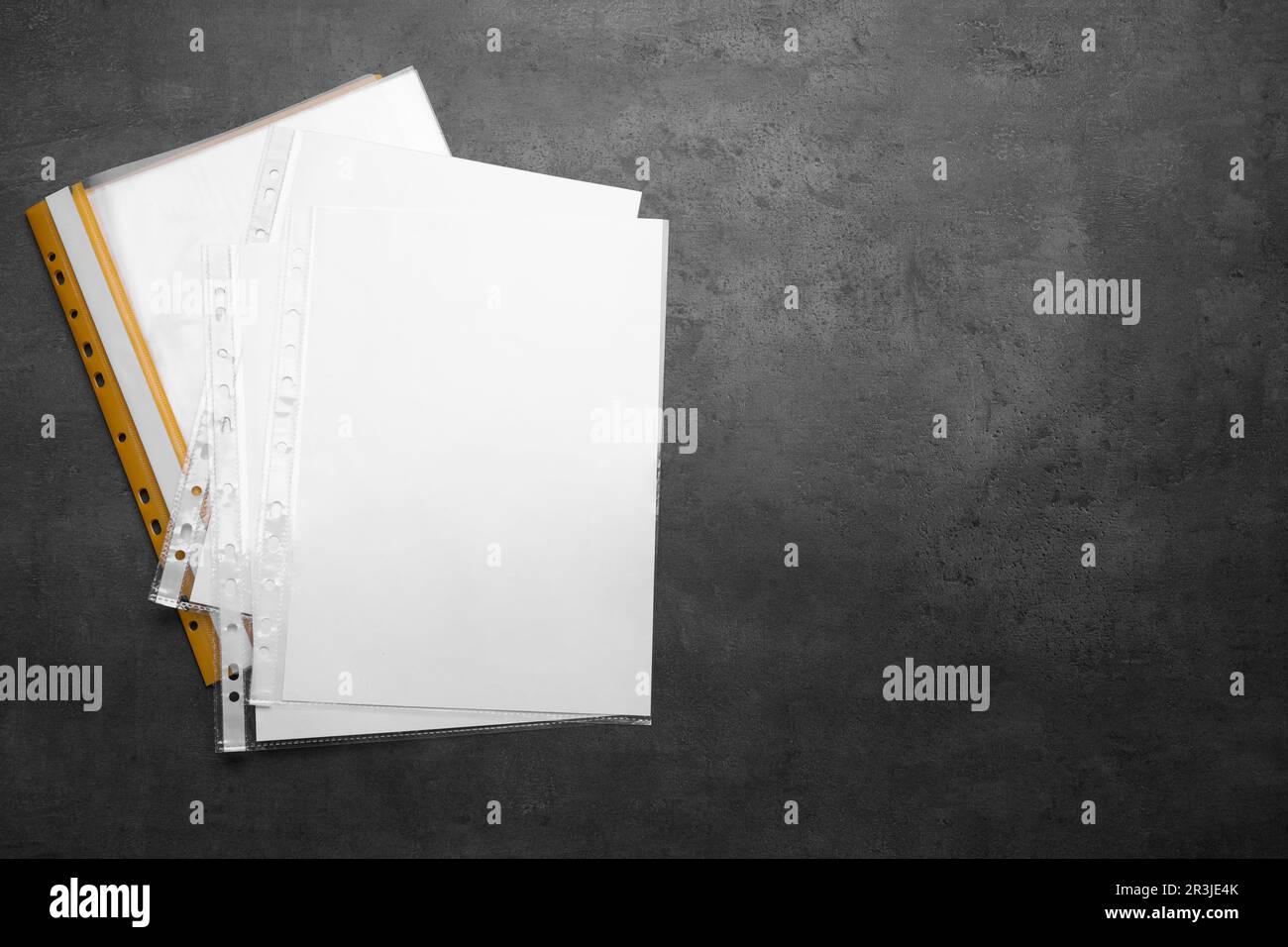 File folder with punched pockets and paper sheets on grey background ...