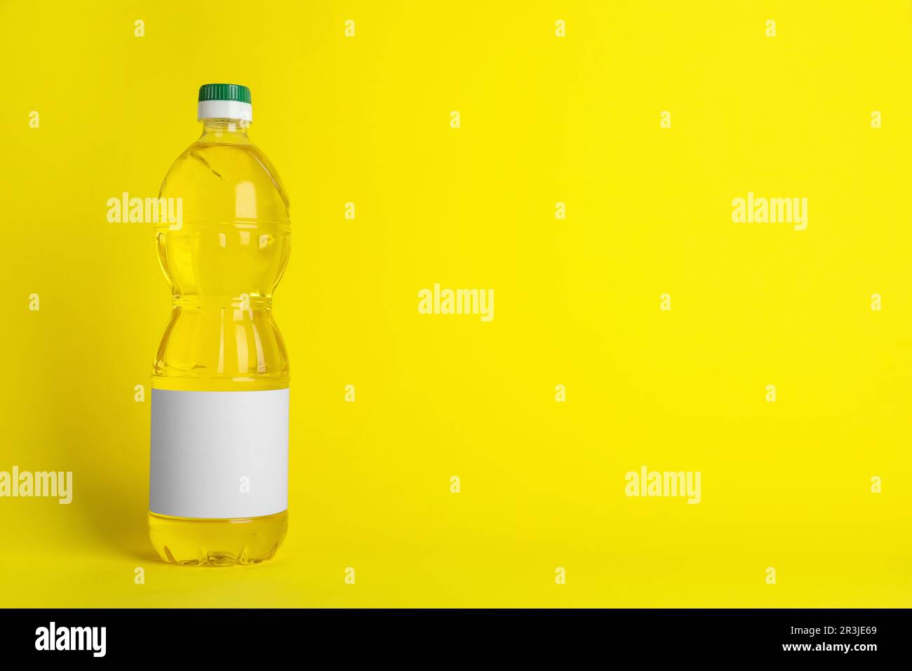 Bottle of cooking oil on yellow background. Space for text Stock Photo ...