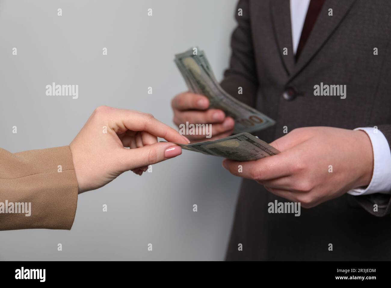 Man giving money to woman on light grey background, closeup. Currency ...
