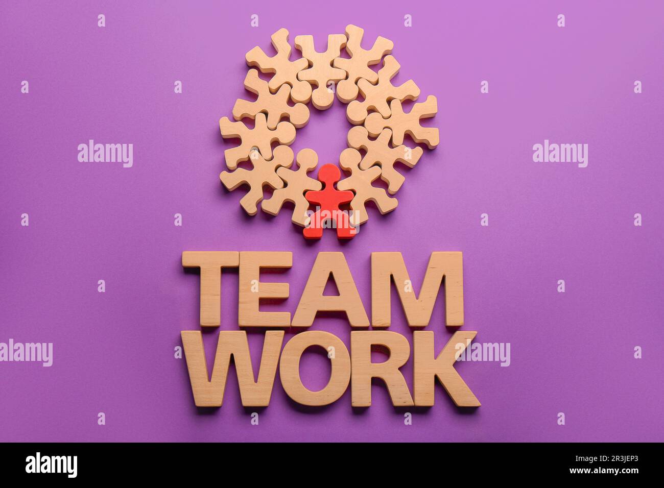 Words Team Work made of wooden letters, red human figure among others ...