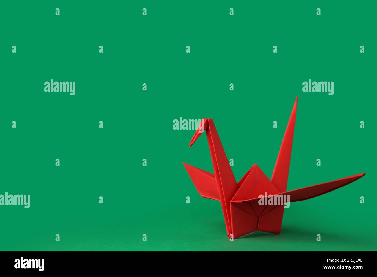 Red paper origami crane on green background, space for text Stock Photo ...