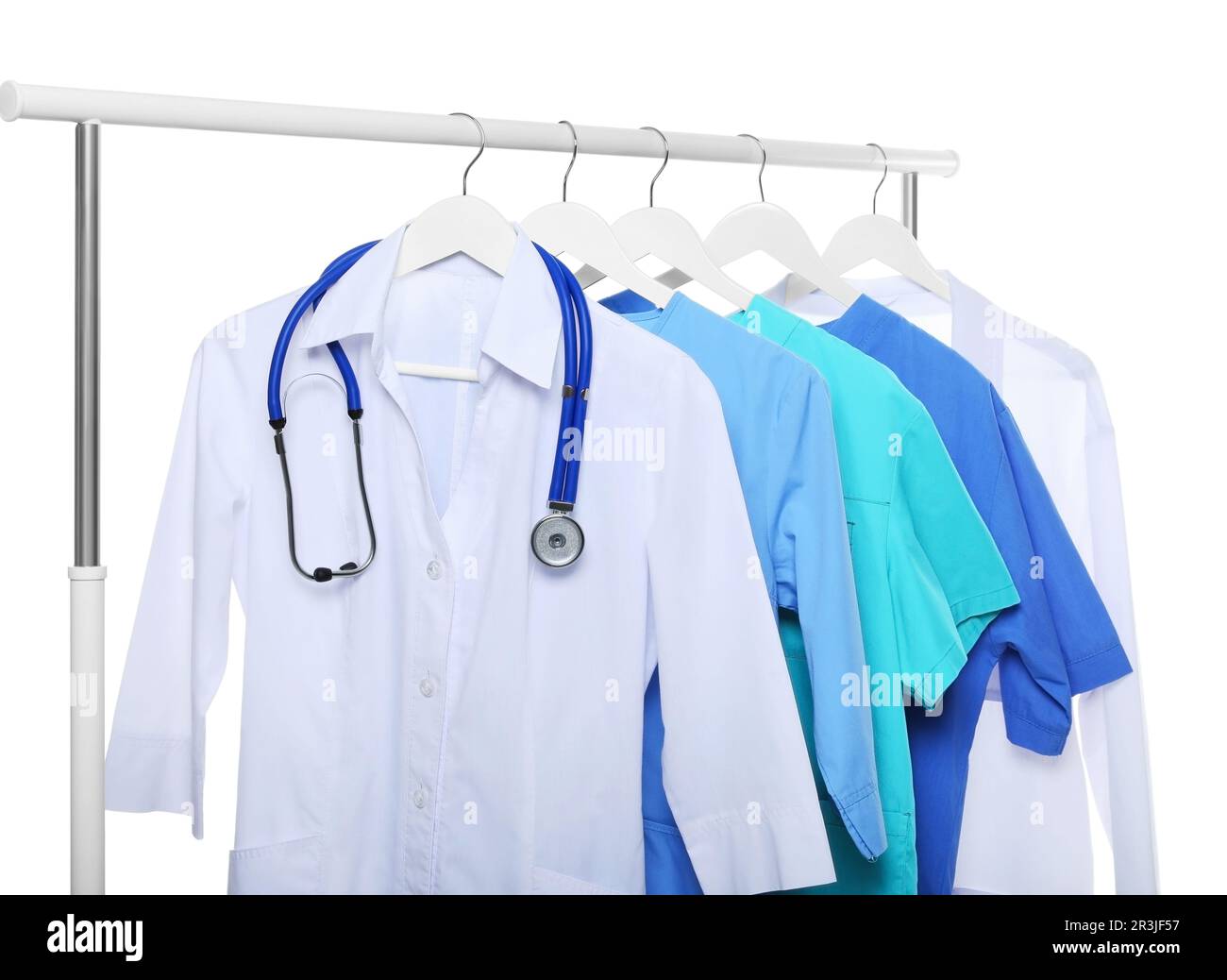Doctor's gown with stethoscope and different medical uniforms on rack ...