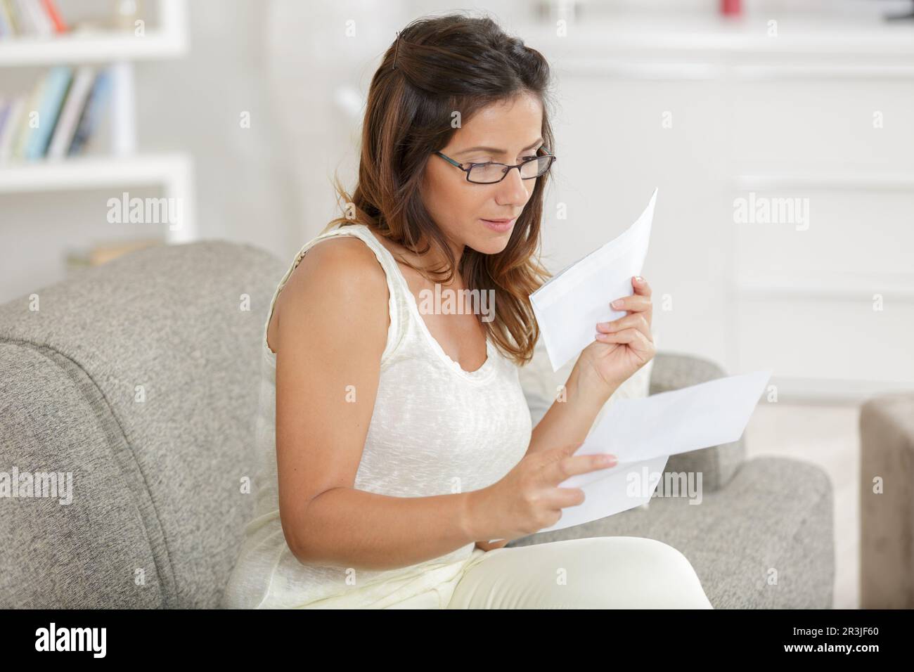 satisfied woman reading a letter at home Stock Photo - Alamy