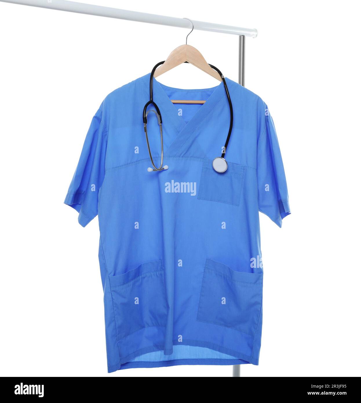 Light blue medical uniform and stethoscope on rack against white ...