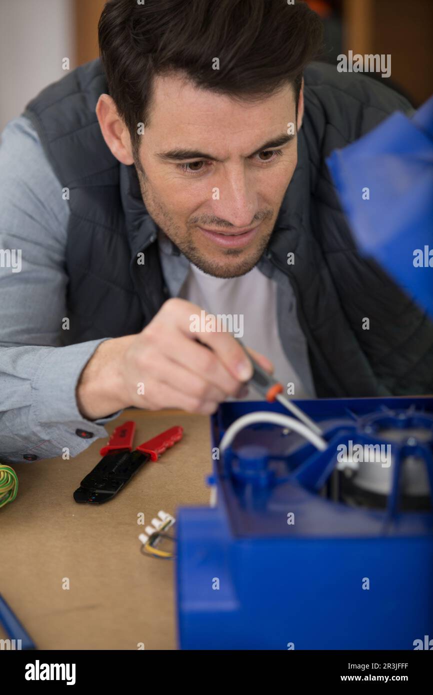 craftsman using screw to remove the machine cover Stock Photo - Alamy