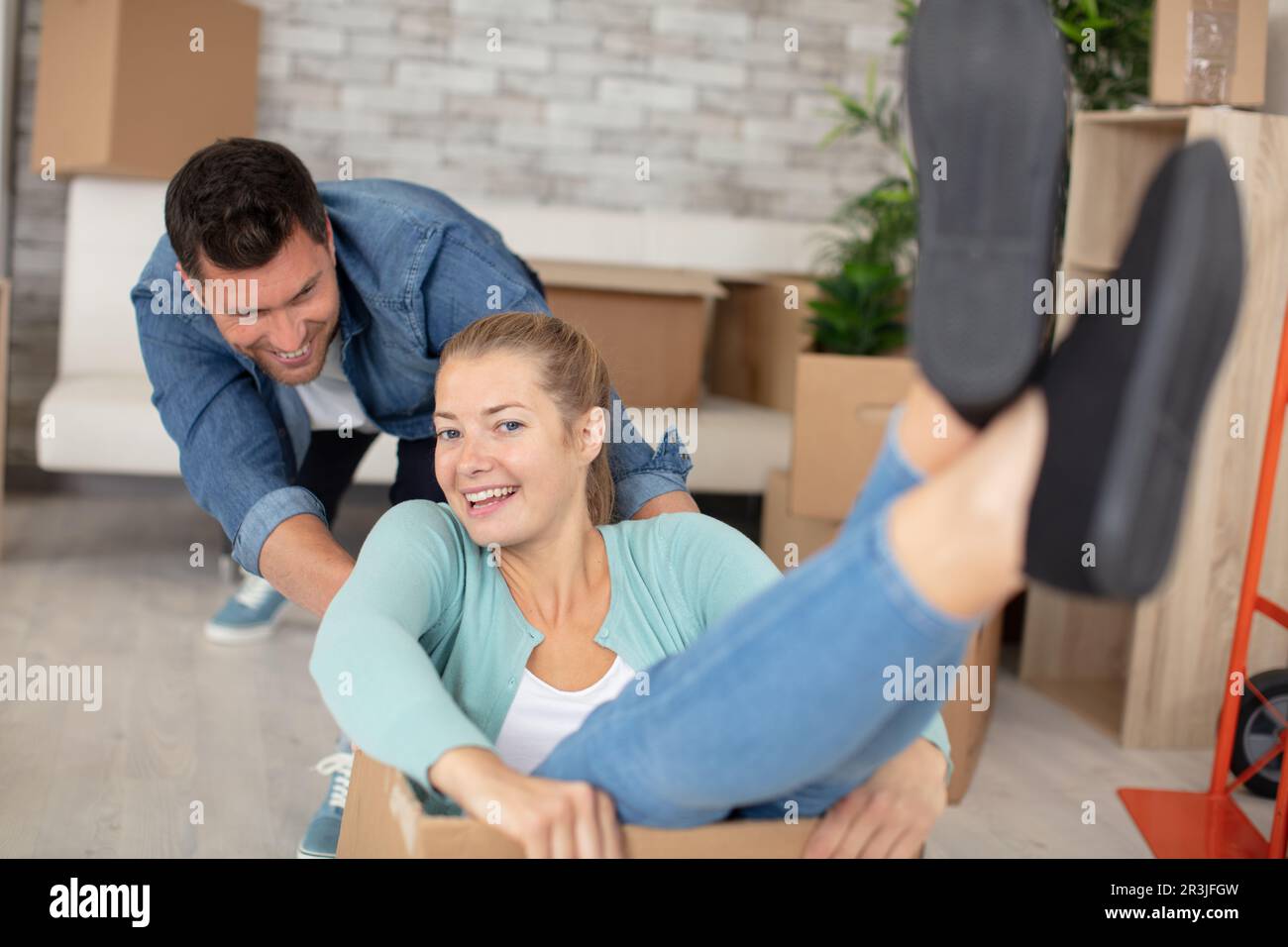 man pushing woman in cardboard box Stock Photo - Alamy